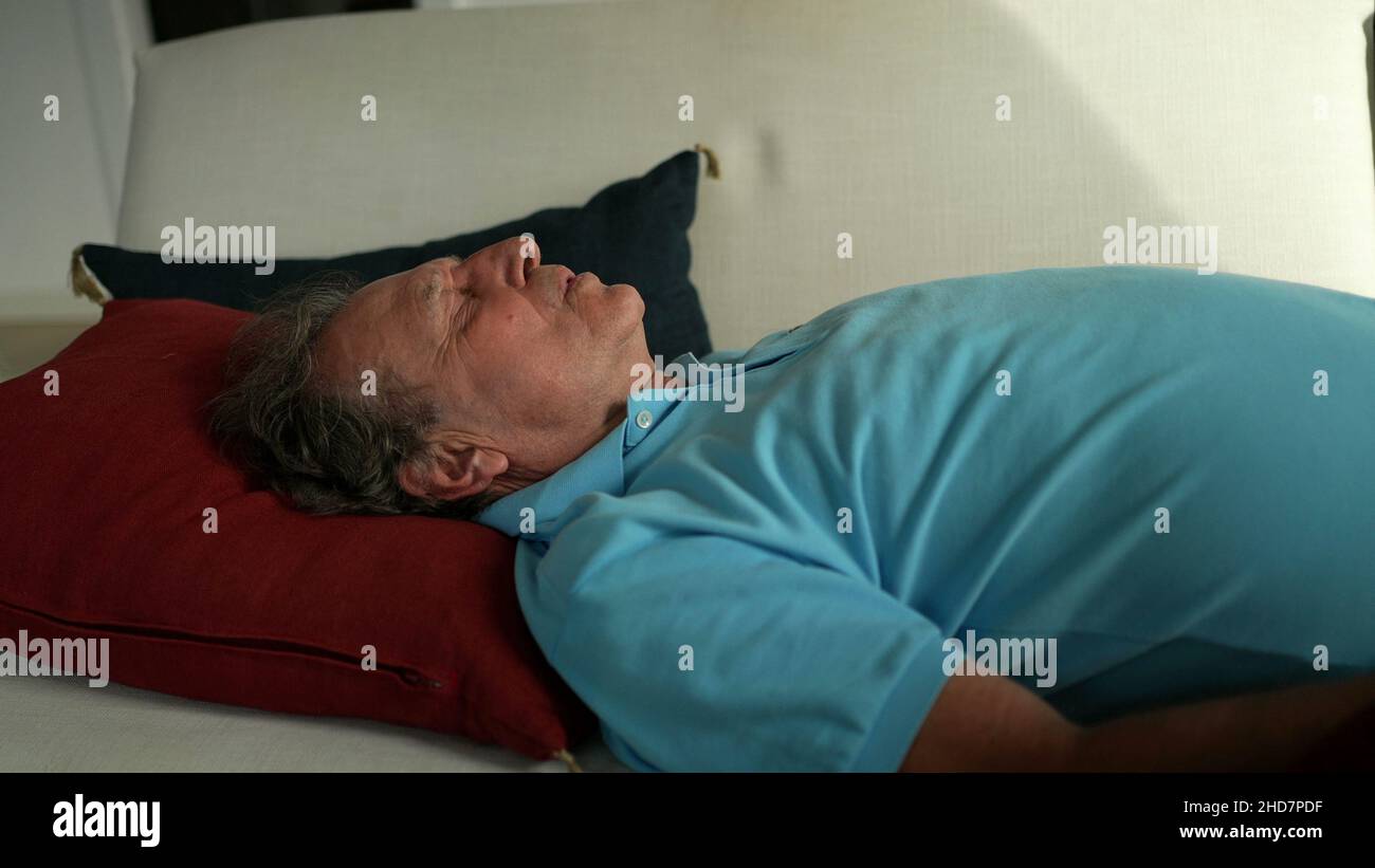 Older man lying in sofa resting. Senior person napping Stock Photo - Alamy