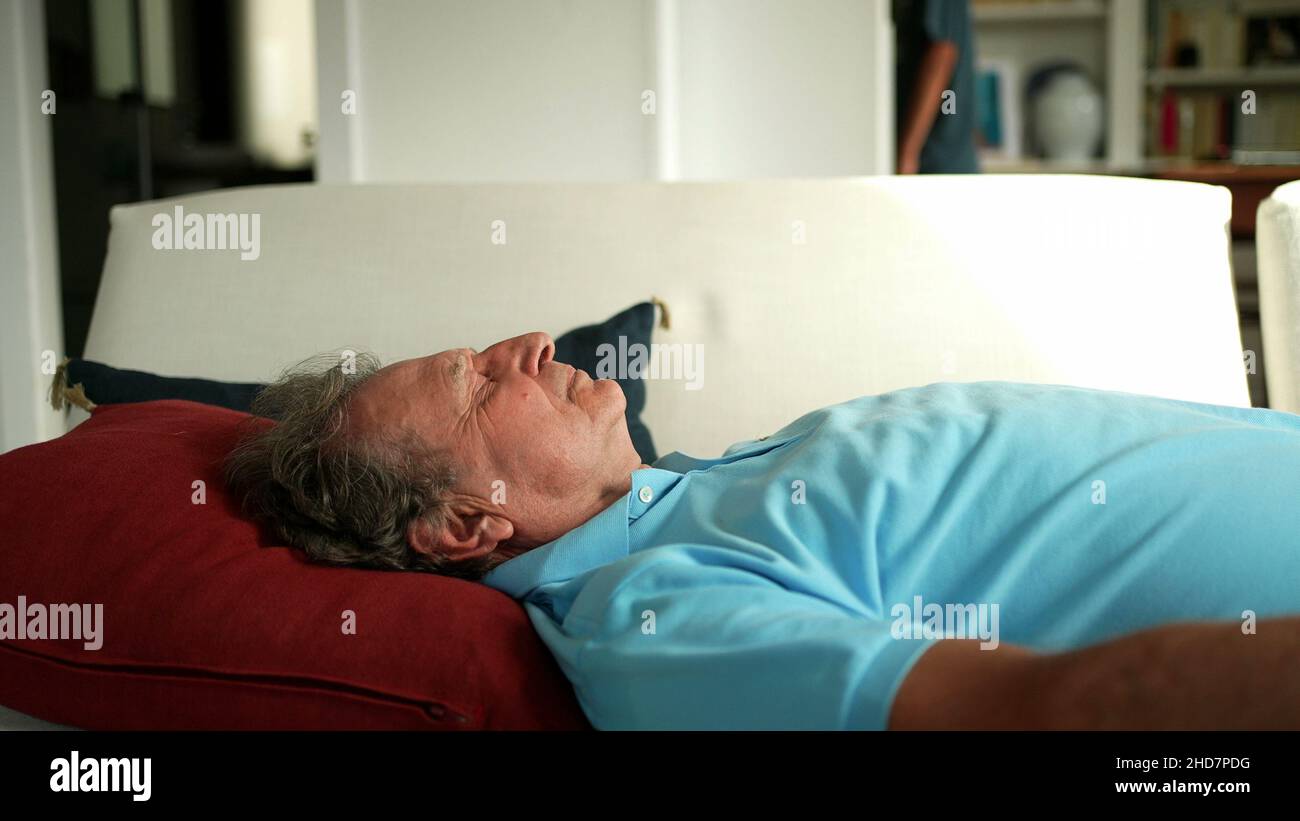 Older man lying in sofa resting. Senior person napping Stock Photo - Alamy