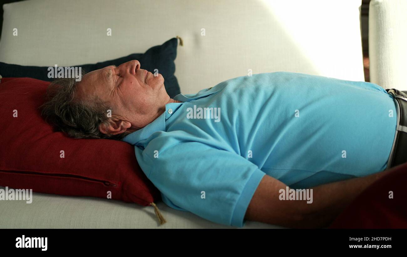 Older man lying in sofa resting. Senior person napping Stock Photo - Alamy