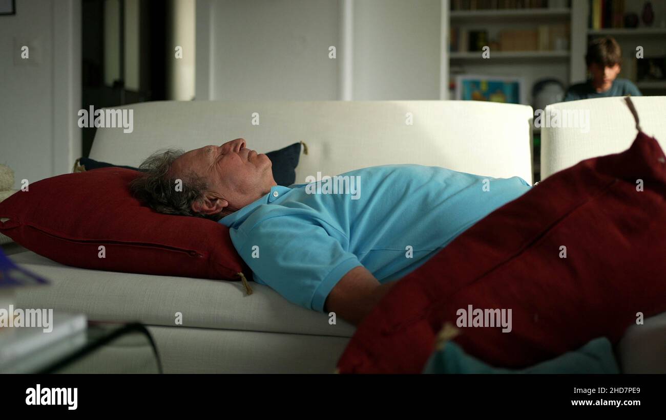 Older man lying in sofa resting. Senior person napping Stock Photo - Alamy