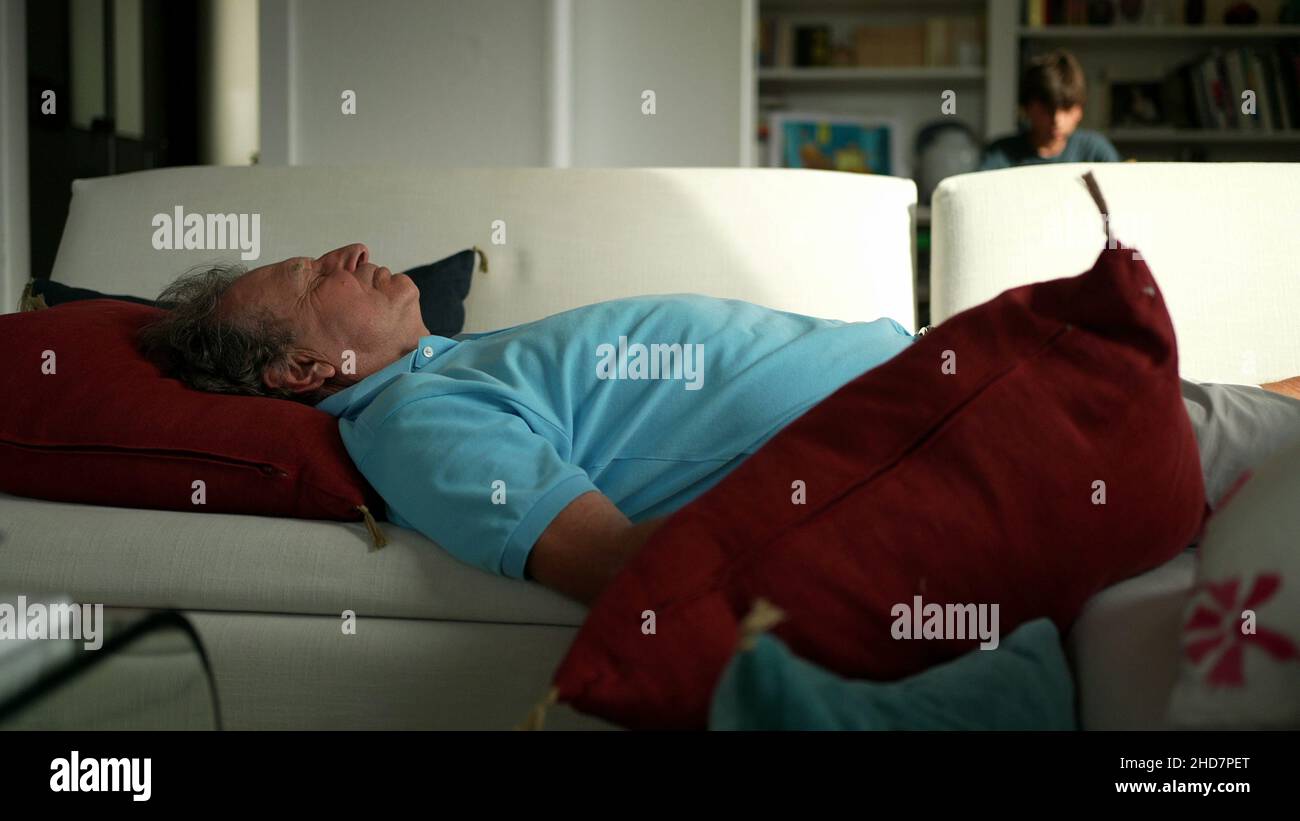 Older man lying in sofa resting. Senior person napping Stock Photo - Alamy
