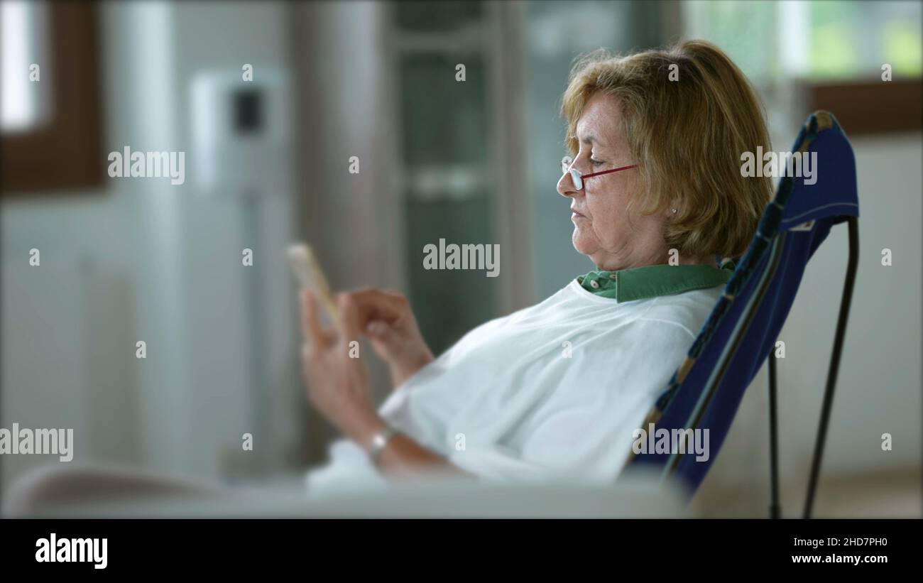 Older woman using phone, senior person holding smartphone touching ...