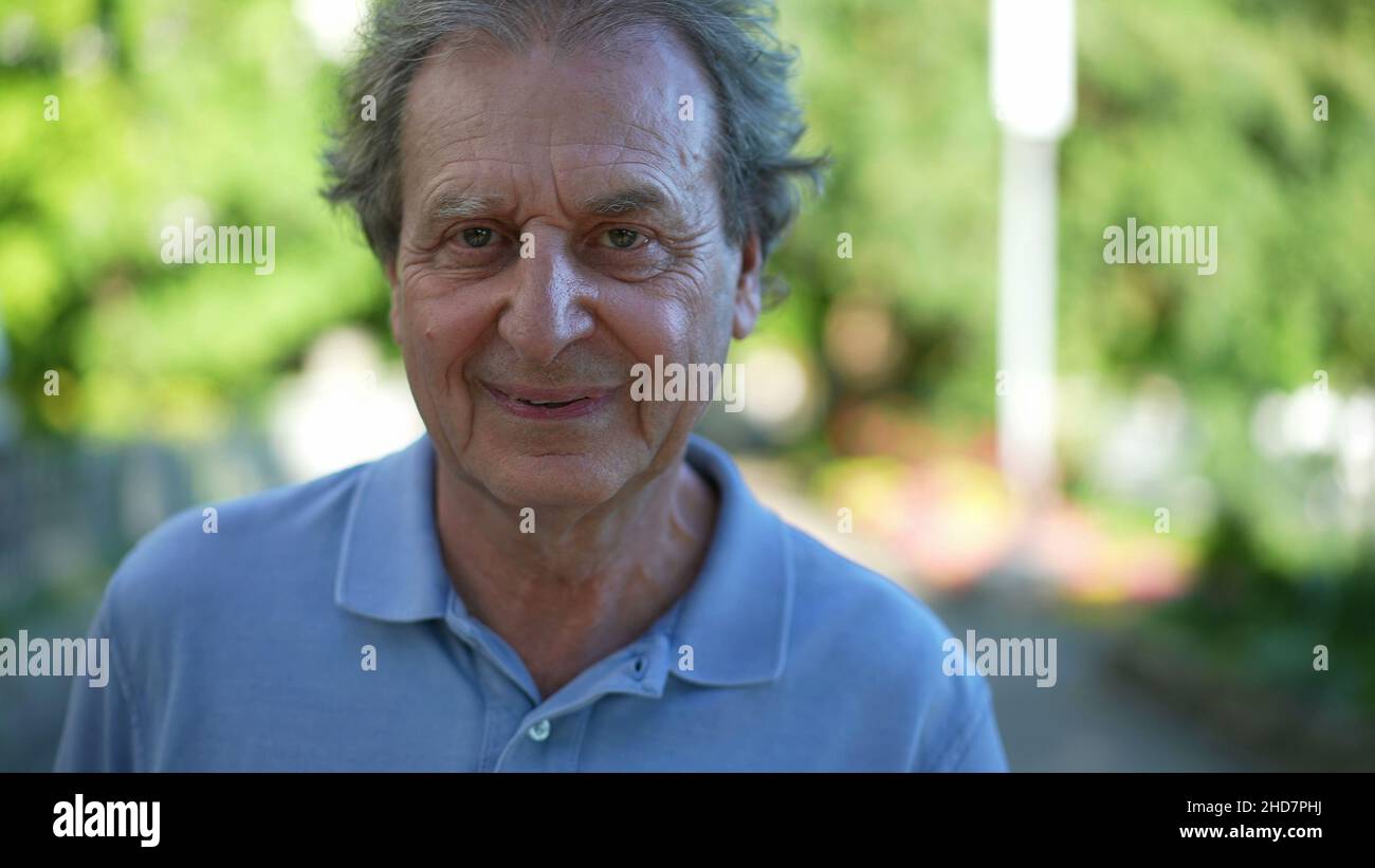 One happy older man walking outside during sunny day, pensive ...