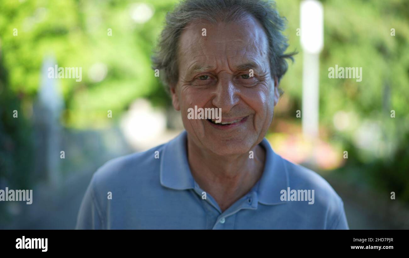 One happy older man walking outside during sunny day, pensive ...