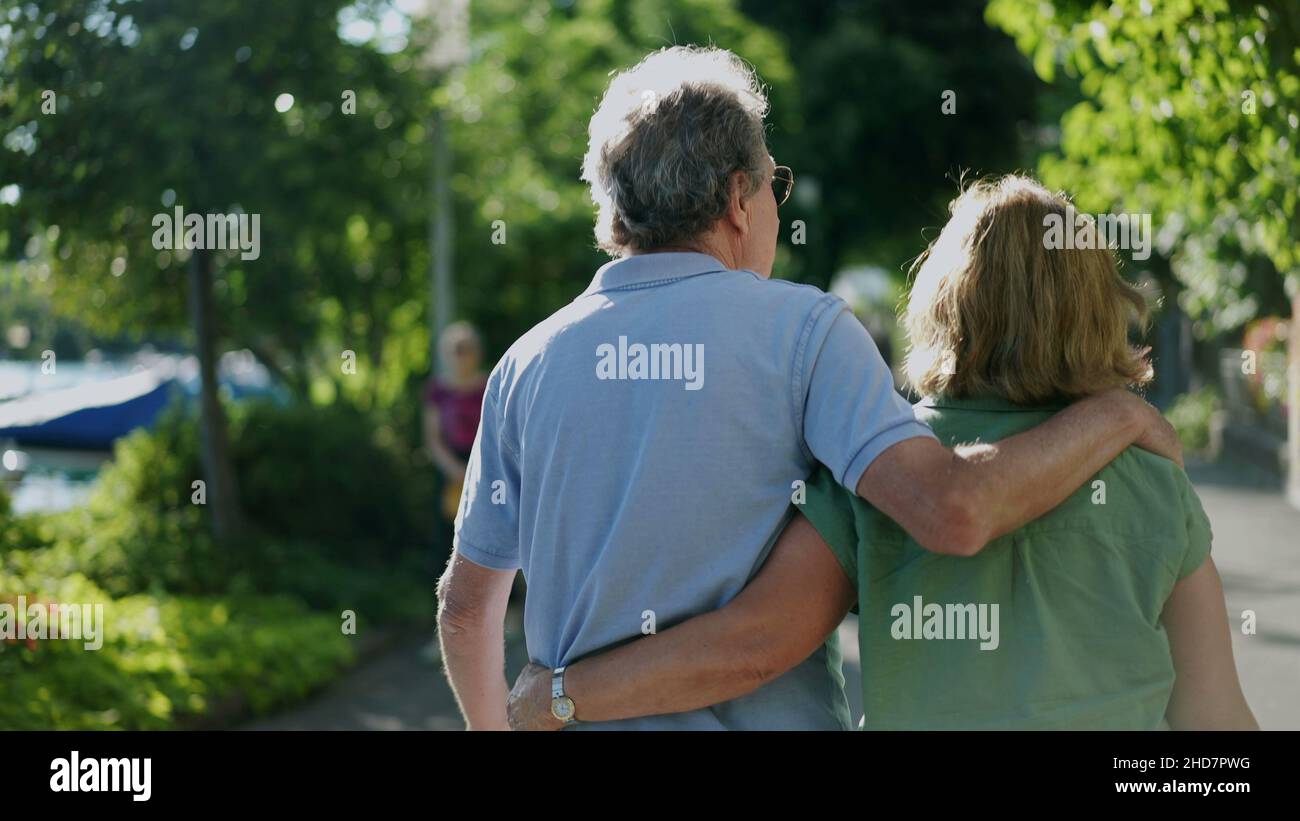 Romantic senior husband putting arm around wife, back view of older ...