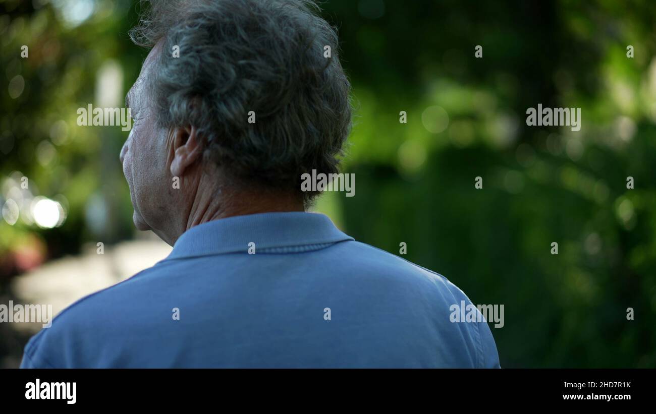 Senior man walking outside in nature. Back of older person in a path ...