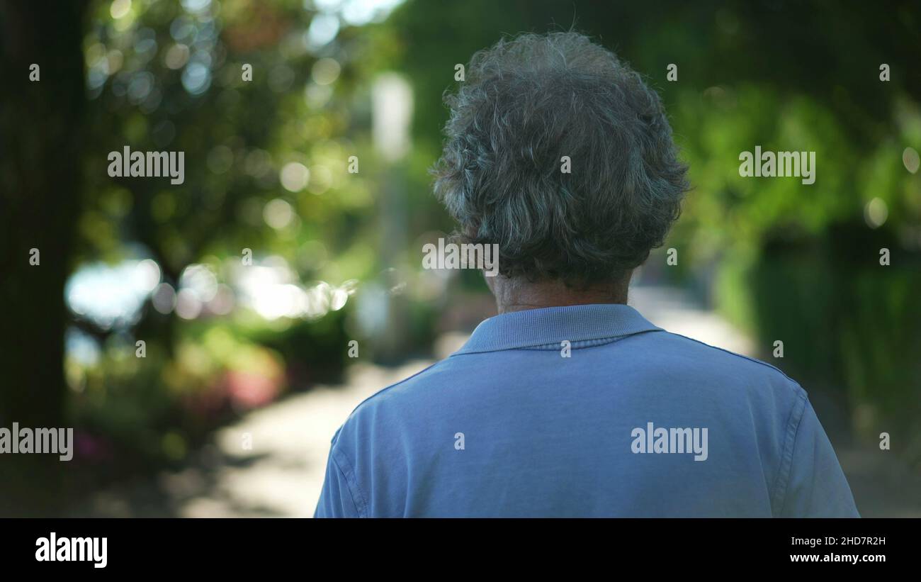 Senior man walking outside in nature. Back of older person in a path ...