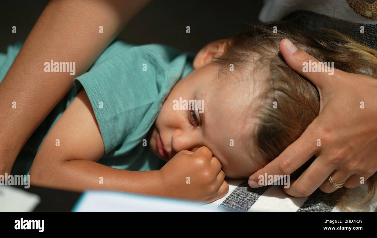 Sleepy child rubbing eye with hand, kid lying down resting Stock Photo ...