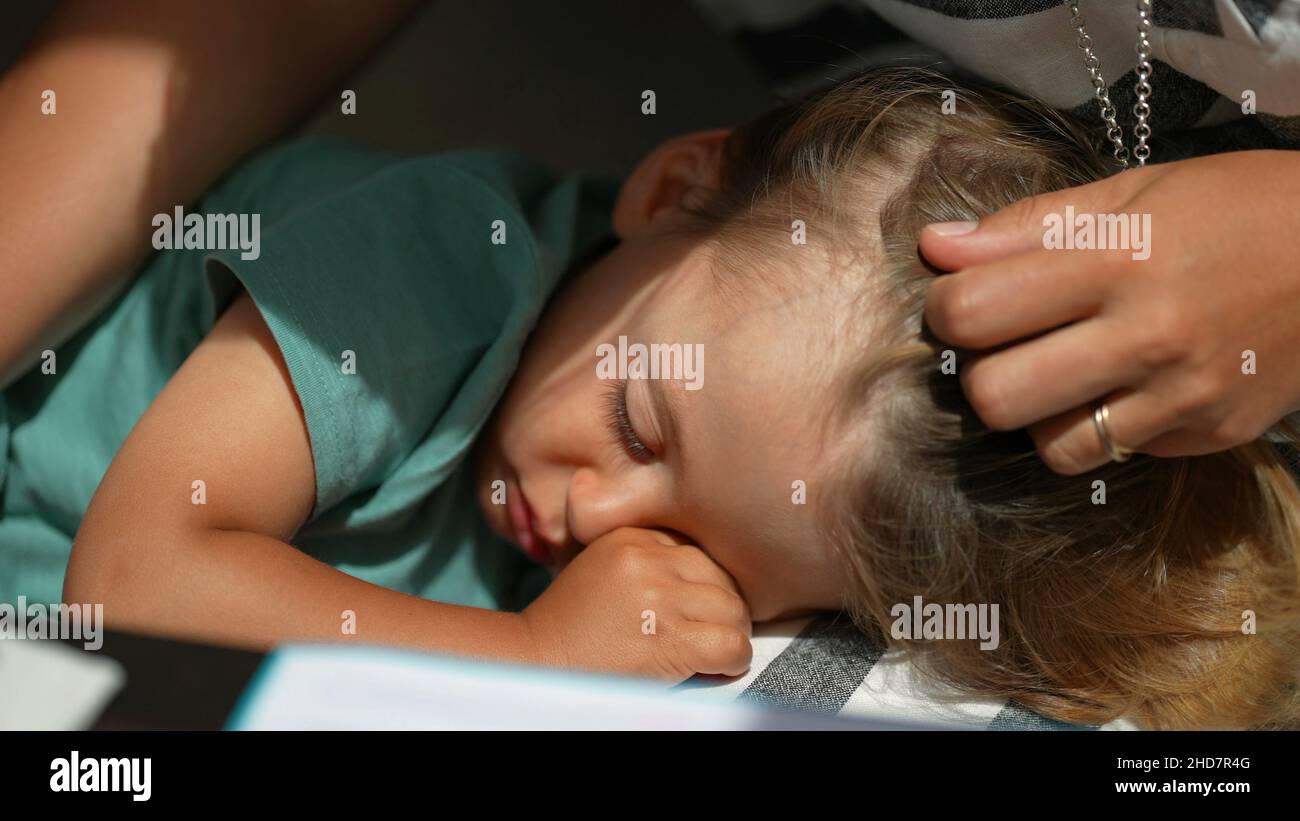 Sleepy child rubbing eye with hand, kid lying down resting Stock Photo ...