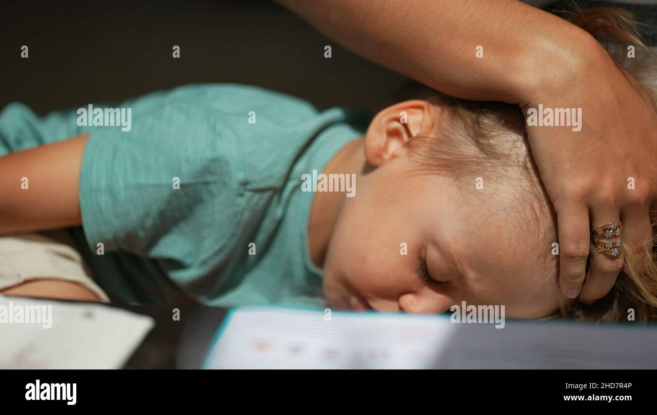 Tired child rubbing eye with hand, mother caressing hair Stock Photo ...