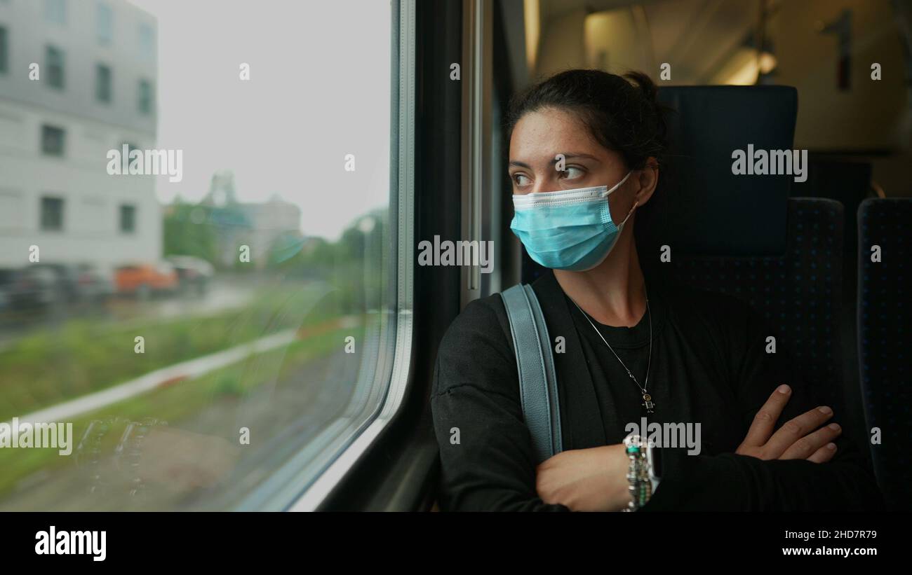 Woman wearing surgical face mask riding train Stock Photo - Alamy