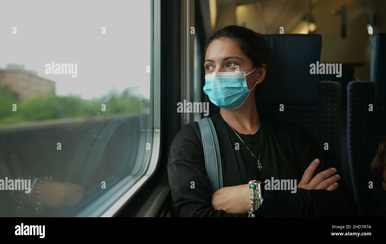 Woman wearing surgical face mask riding train Stock Photo - Alamy