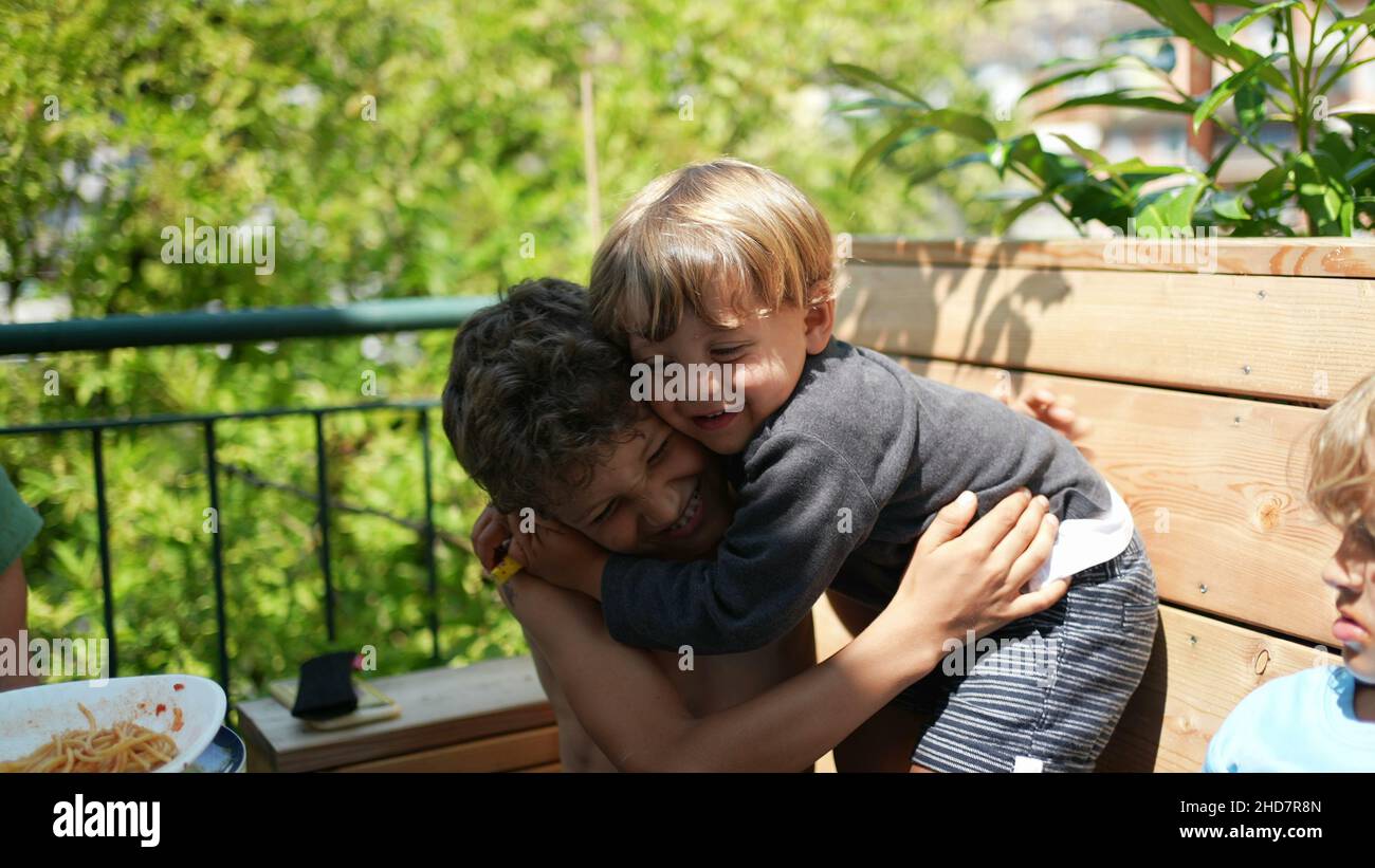 Two brothers hugging outside, smaller sibling embraces brother Stock ...