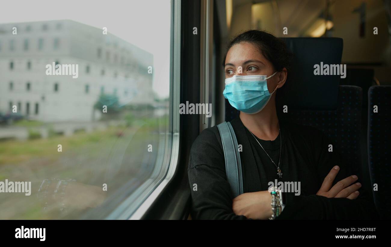 Woman wearing surgical face mask riding train Stock Photo - Alamy