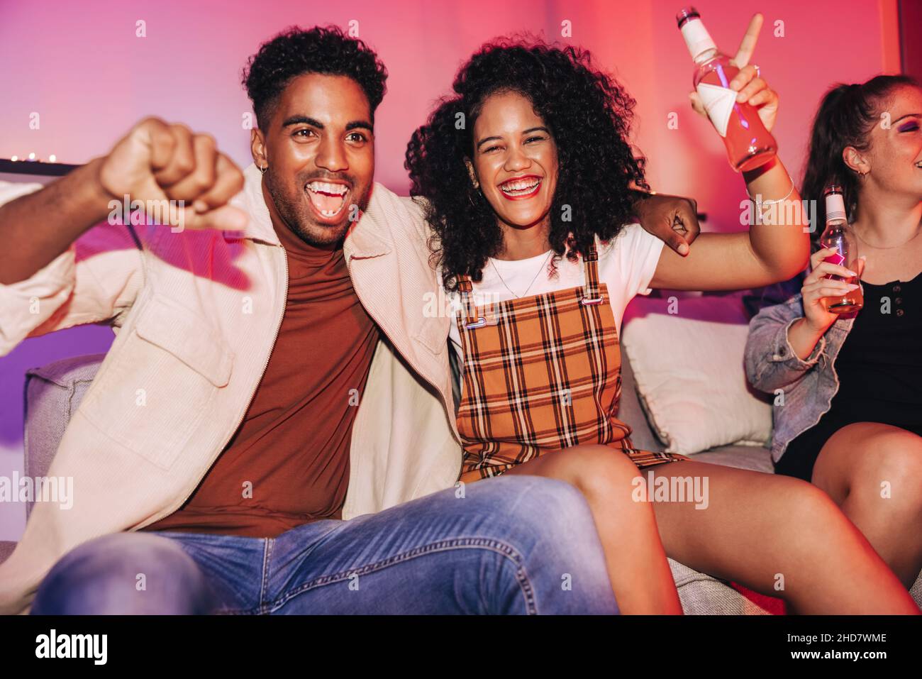 partying in neon light. Group of cheerful generation z friends dancing ...