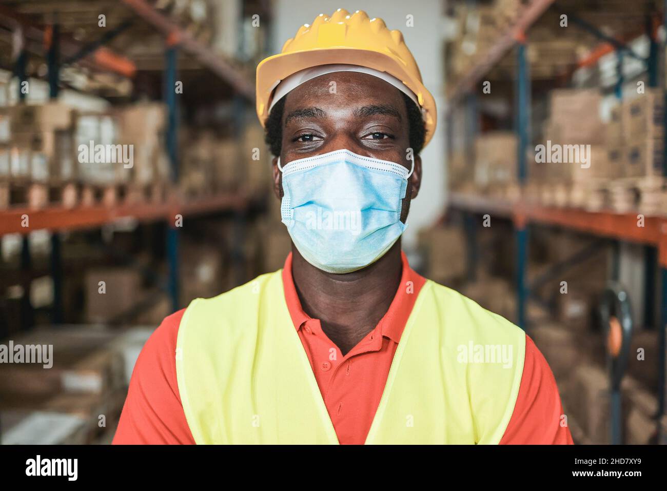 Portrait of african worker man inside warehouse while wearing ...