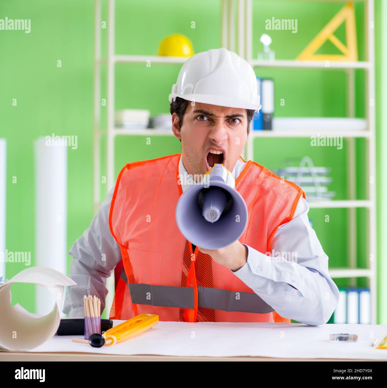 The construction supervisor with loudspeaker sitting in the office ...