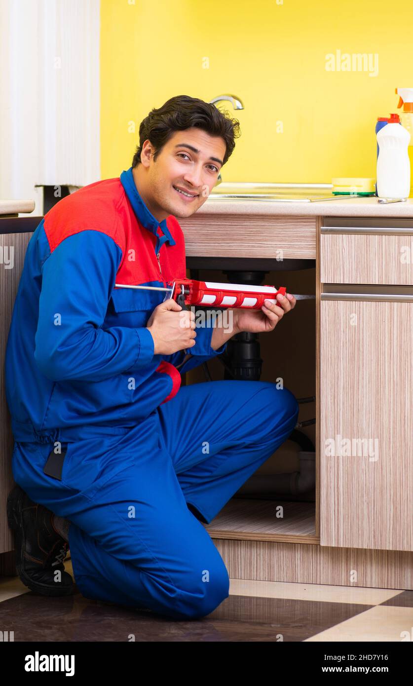 The plumber repairing wash basin at kitchen Stock Photo - Alamy