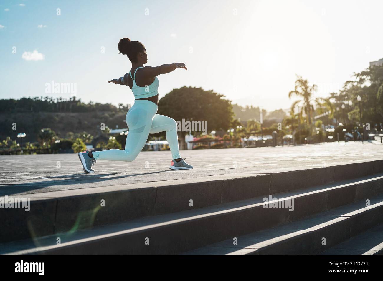 Fit african woman doing stretching exercises outdoor Stock Photo - Alamy