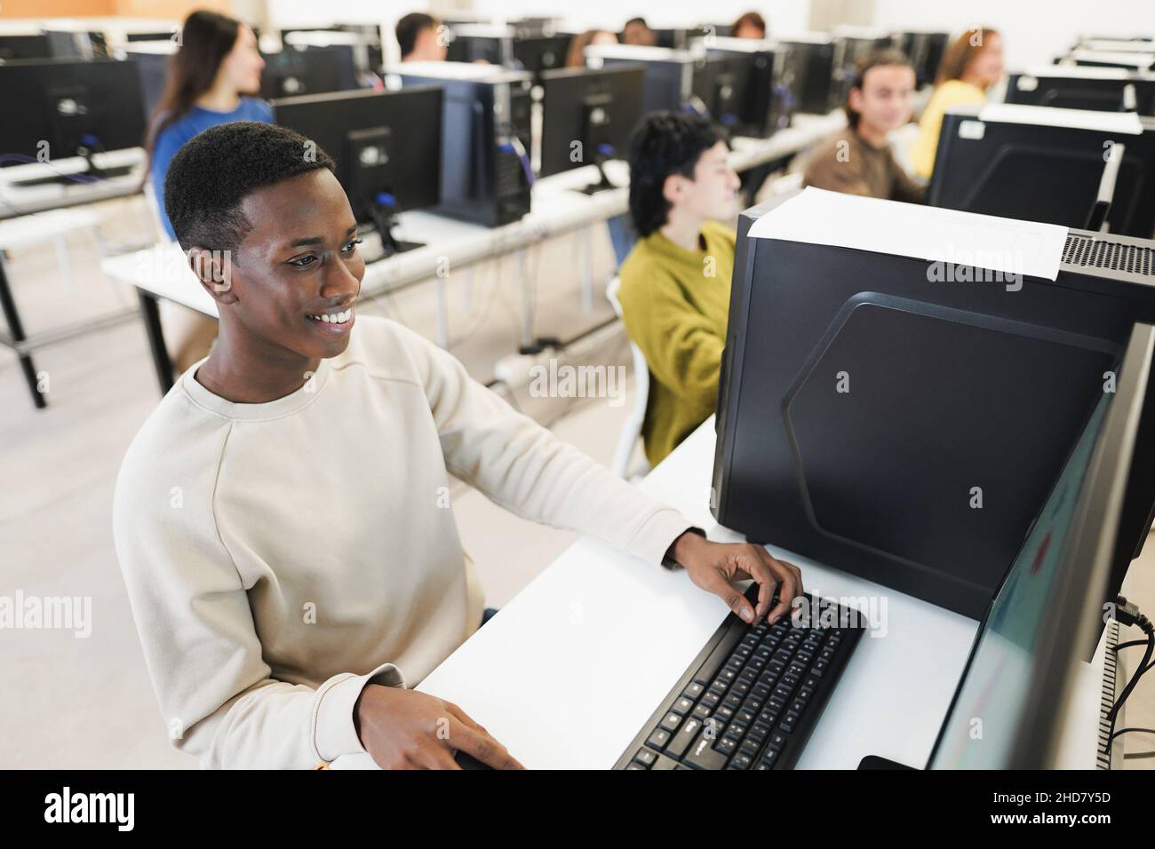 Young african student using computer inside computer room at school ...