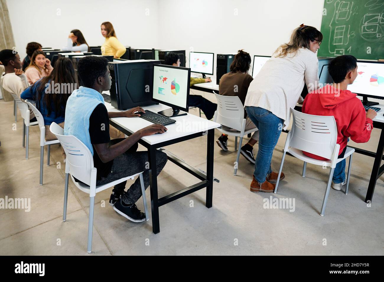 Young students using computers inside business class at school - Focus ...