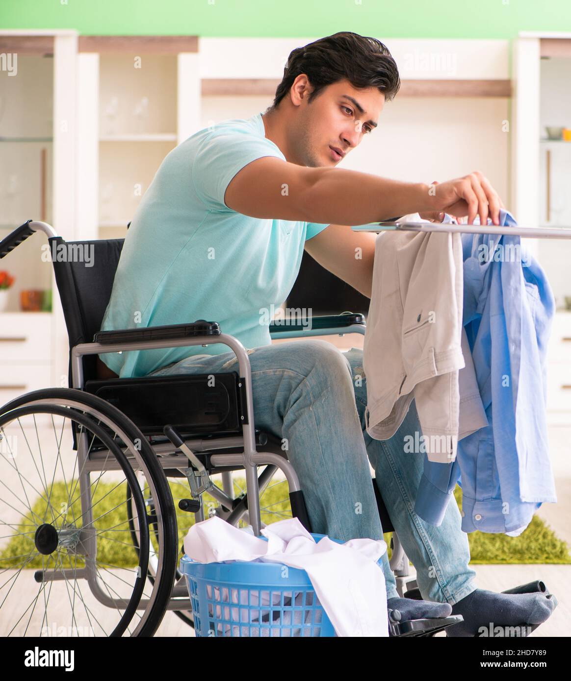 The disabled man on wheelchair doing laundry Stock Photo - Alamy