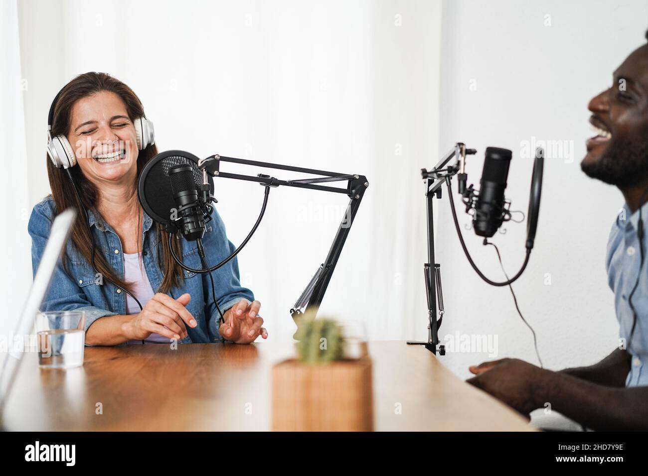 Multiracial hosts streaming podcast together at home studio - Focus on ...