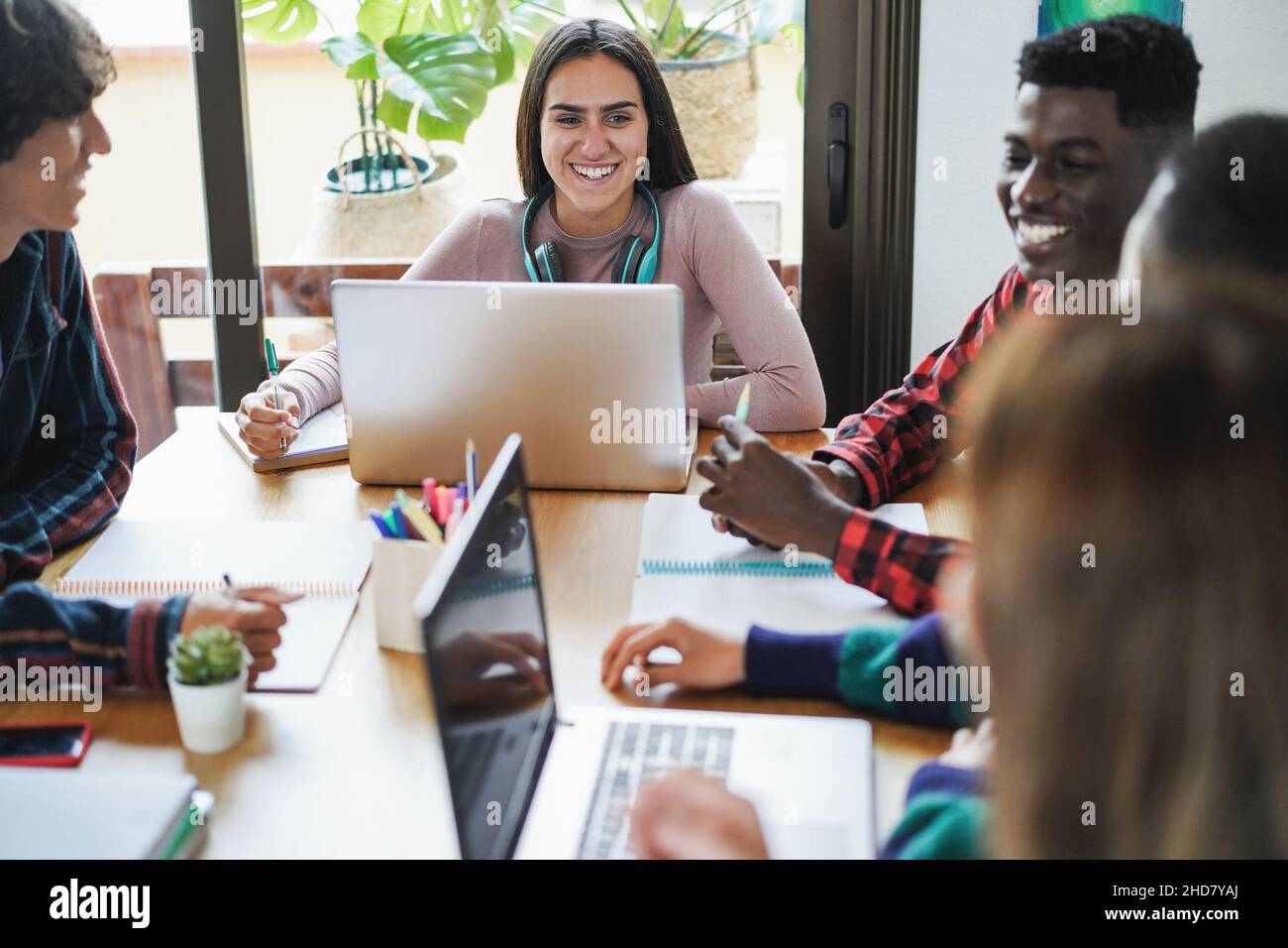 Multiracial students using laptop computers while studying together at ...