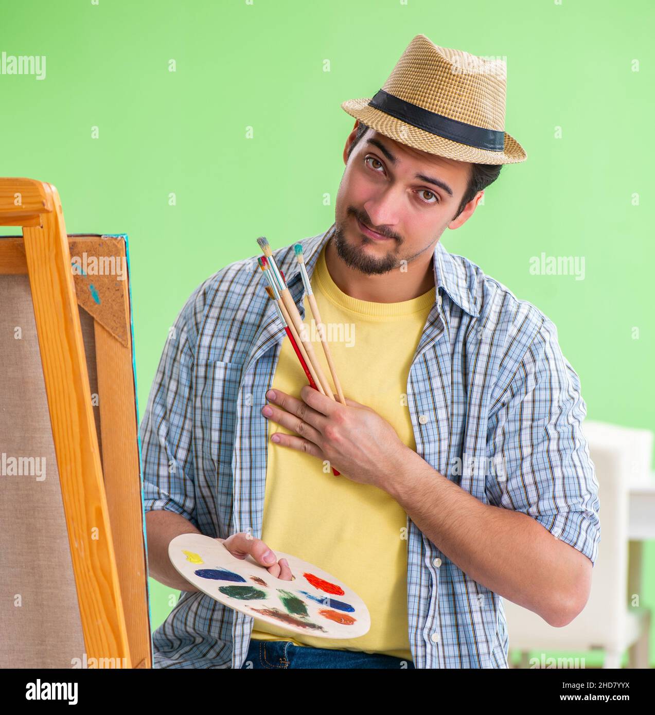 The young male artist working on new painting in his studio Stock Photo ...