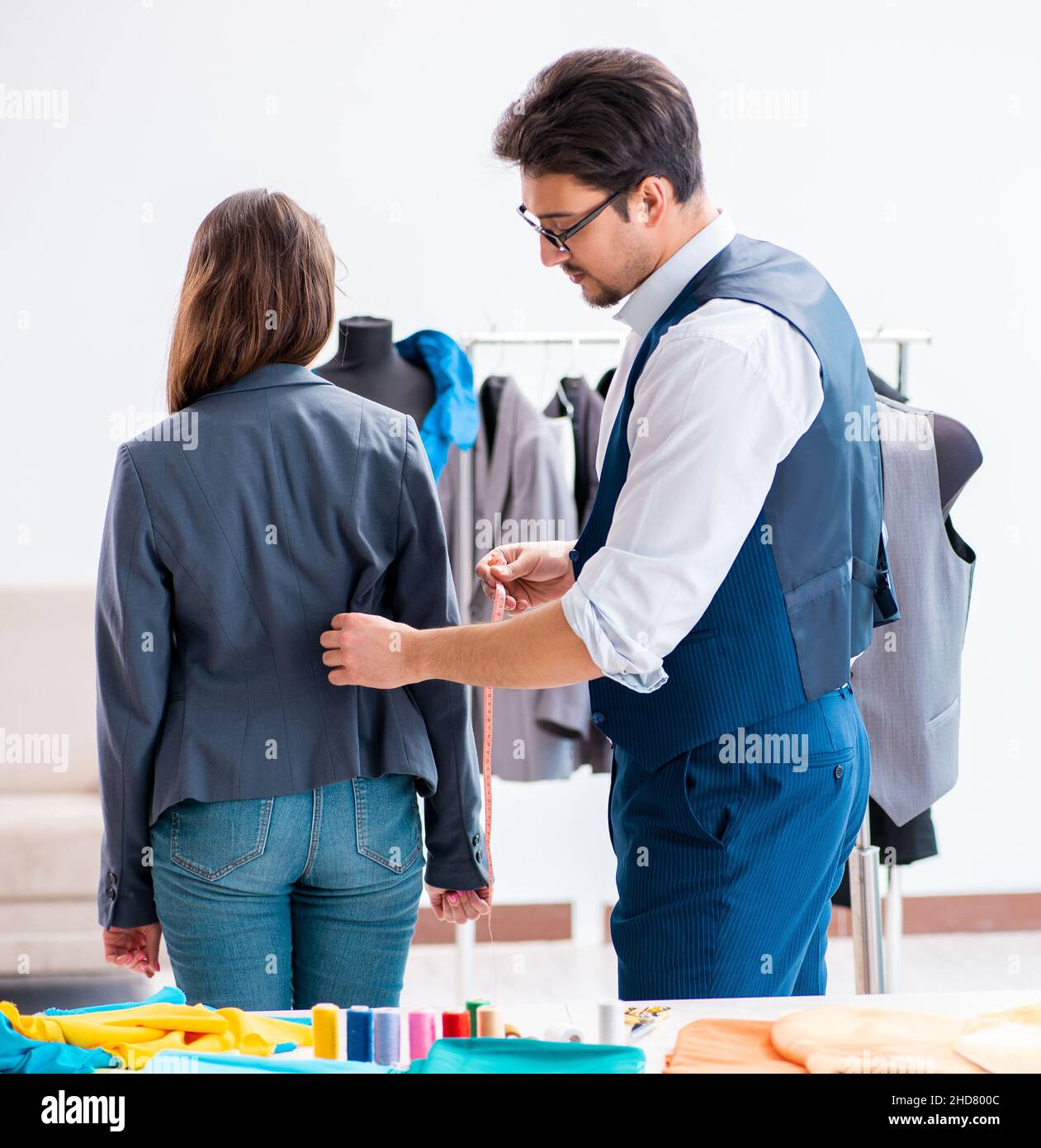 The professional tailor taking measurements for formal suit Stock Photo ...