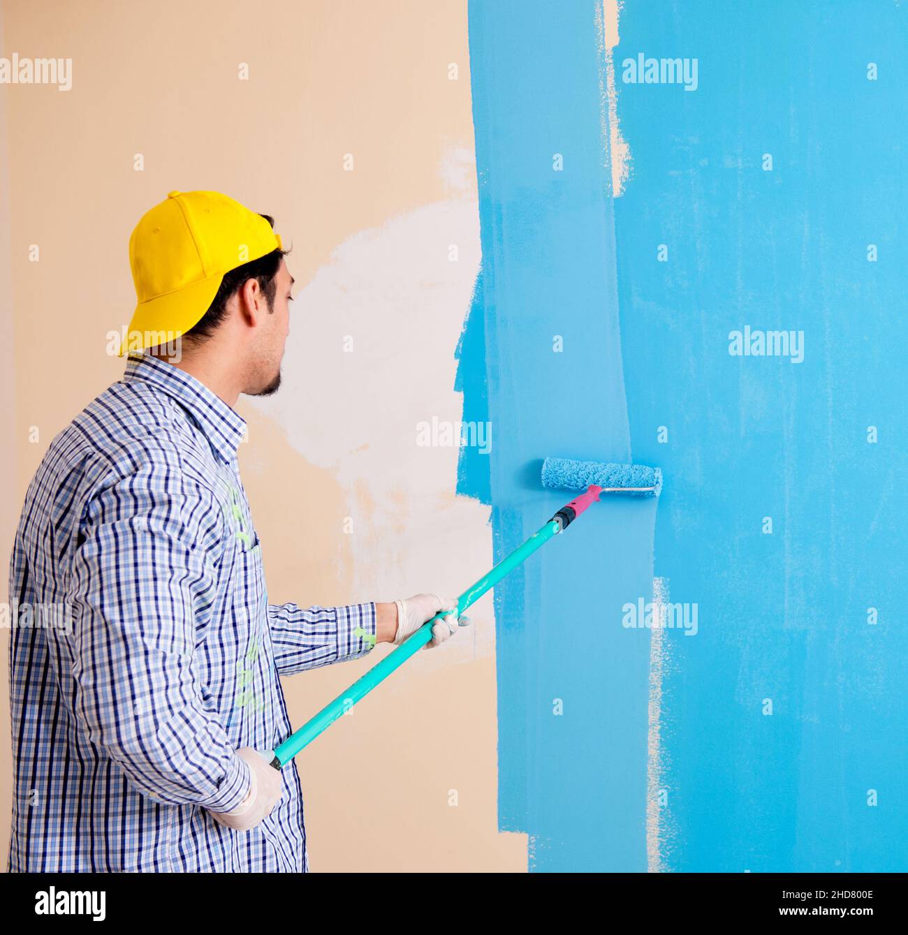 The painter man painting the wall at home Stock Photo - Alamy