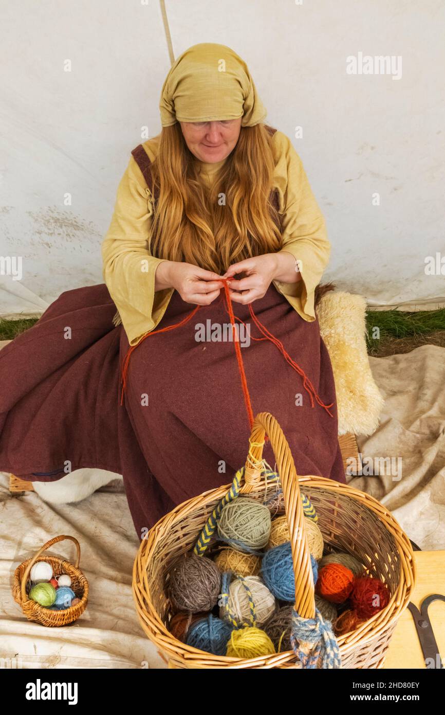 Female participant dressed in medieval costume spinning wool hi-res ...