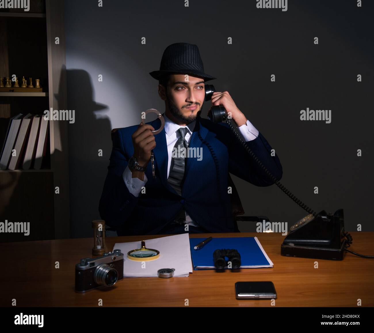 The detective sitting in dark room in vintage concept Stock Photo - Alamy
