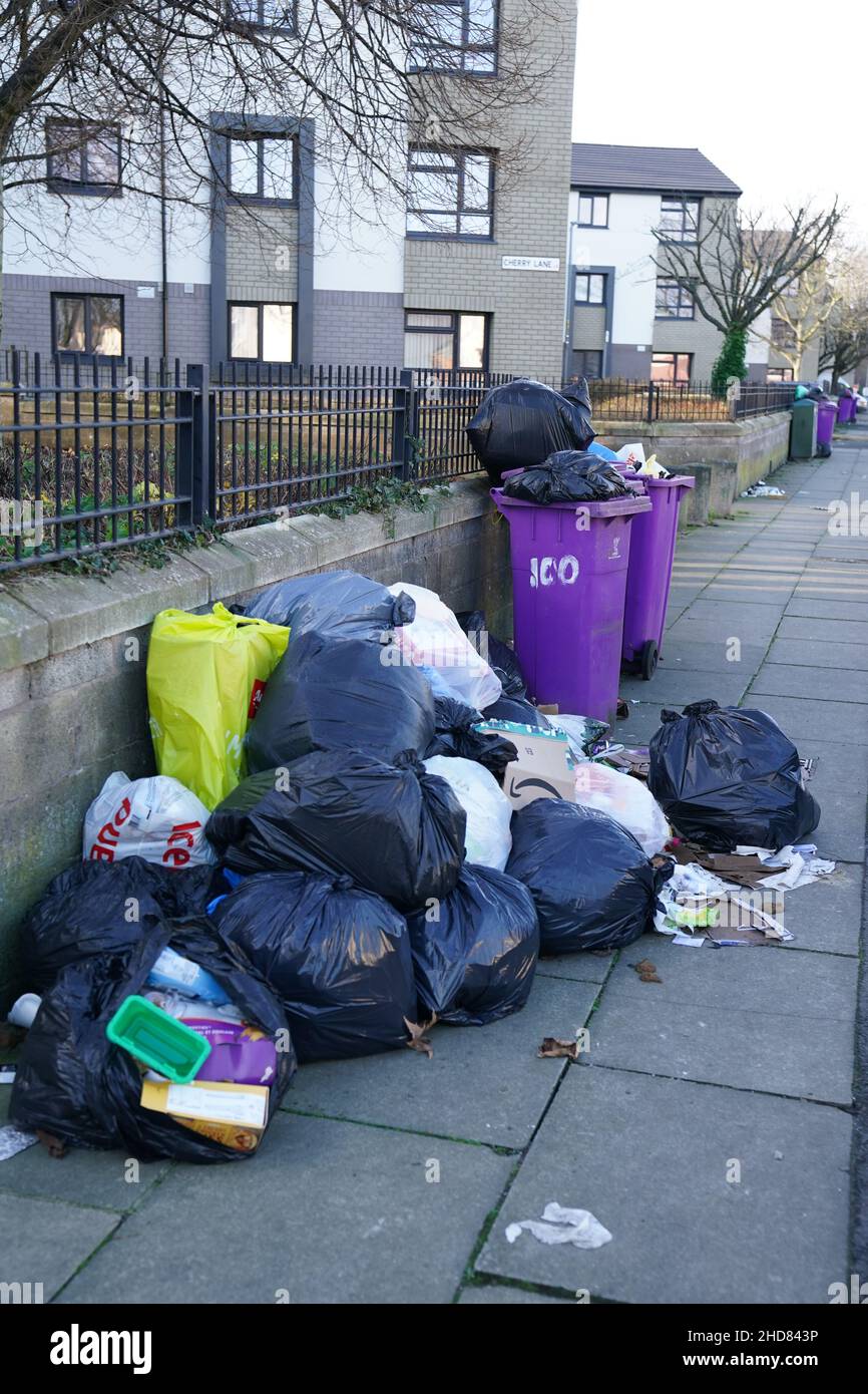 Overflowing bins awaiting collection by refuse workers on Cherry Street ...