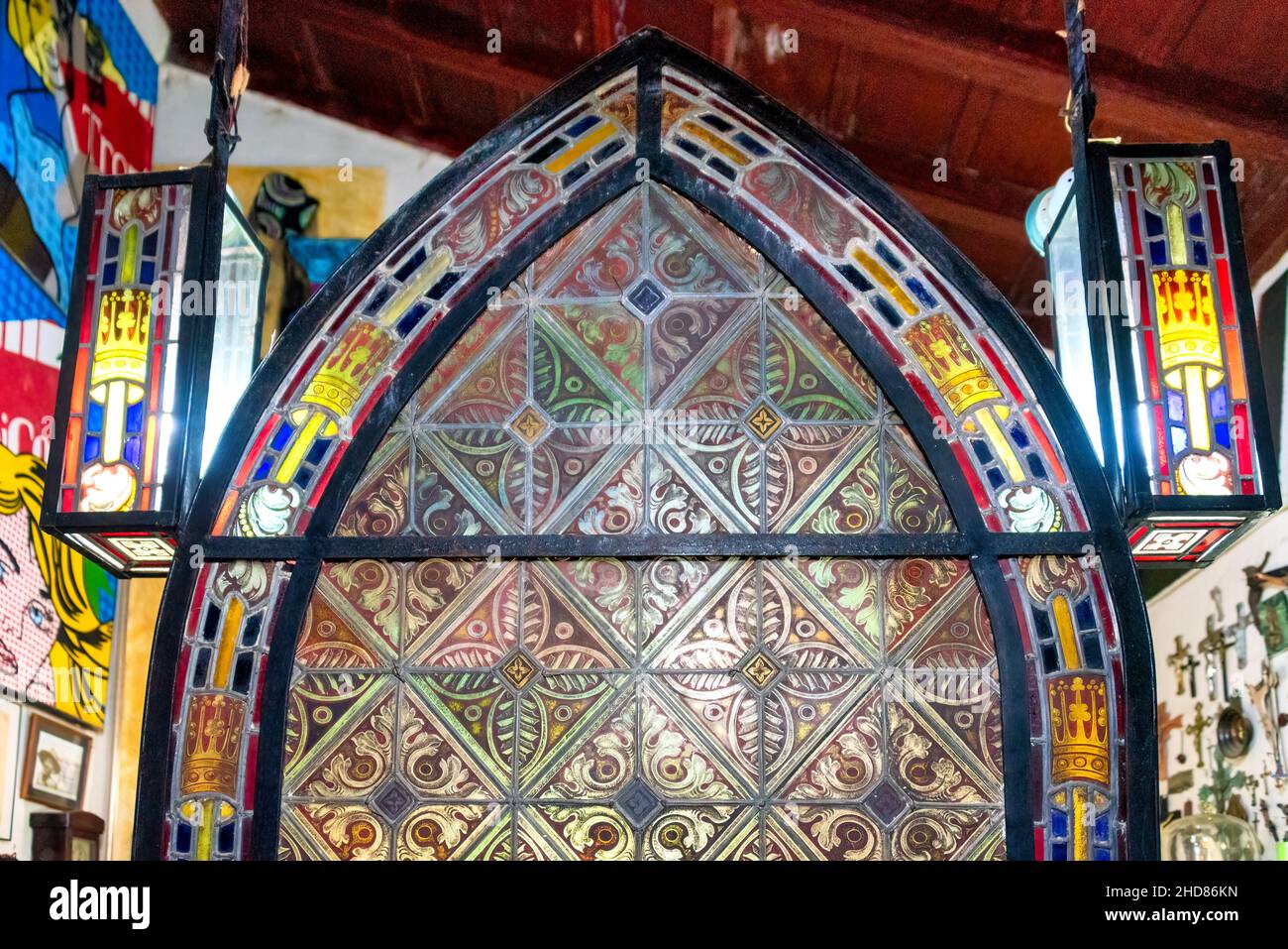 Colonial stained glass window. Collection of antique objects inside the ...