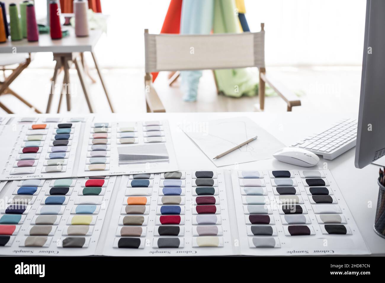 On table of clothing designers with computer, shades, clothes design ...