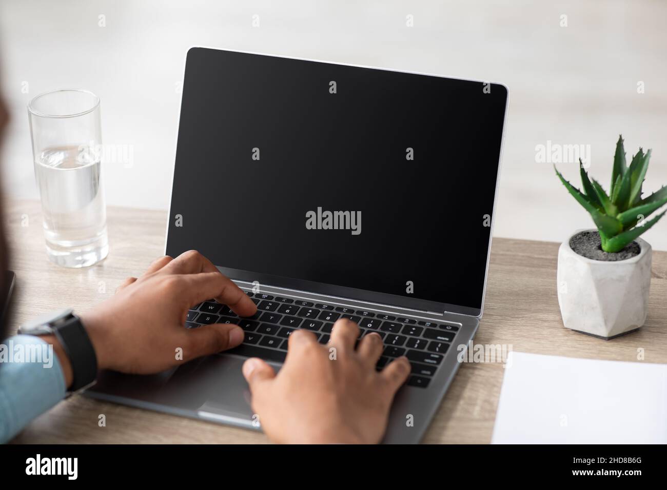 Young african american guy typing on pc with blank screen at workplace ...