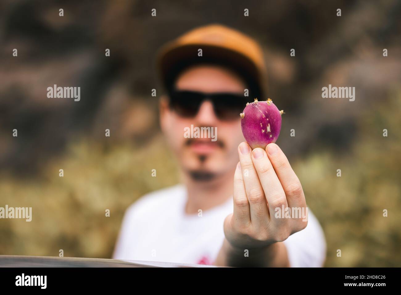 A young man holding a prickly pear Stock Photo - Alamy