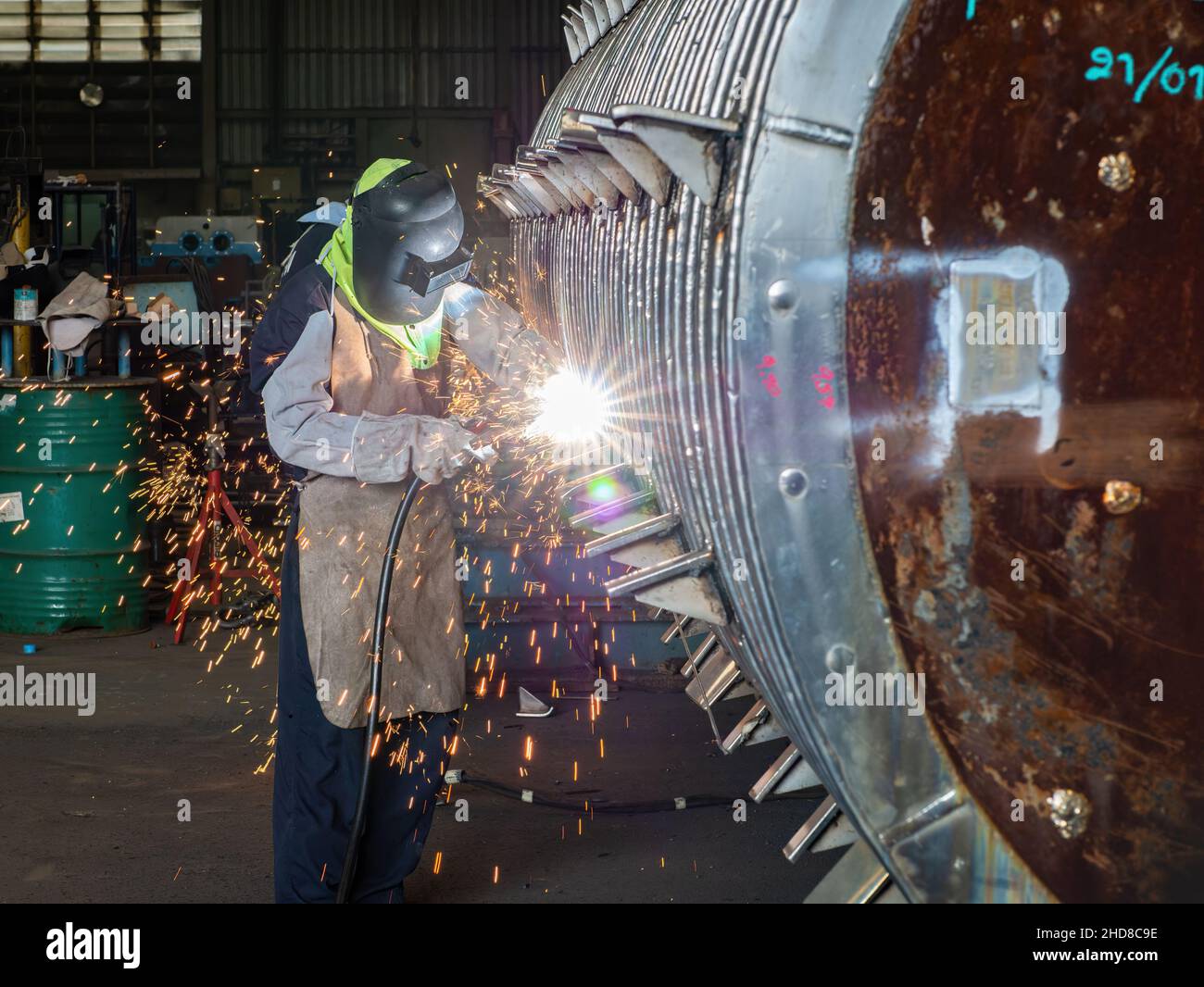 Welders doing refurbishing work on a used rotor for a steam heated ...