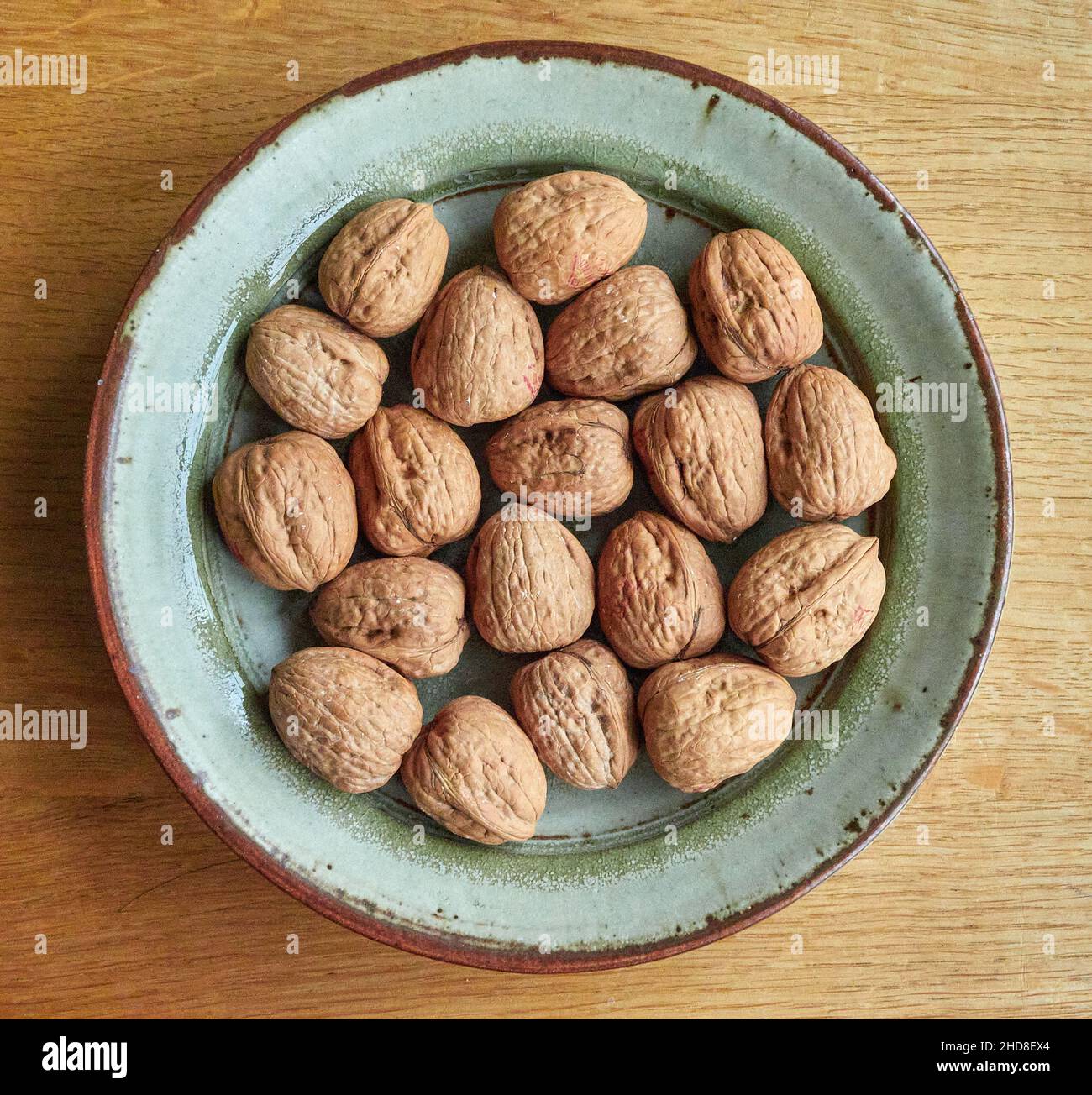 Walnuts in a Richard Batterham stoneware dish on an oak table Stock ...
