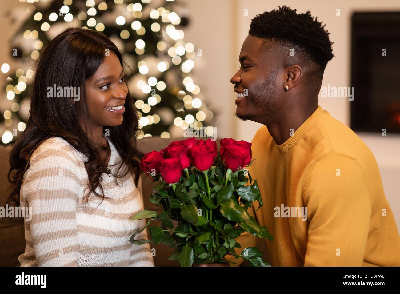 Black Husband Giving Roses To Wife On Valentine At Home Stock Photo - Alamy