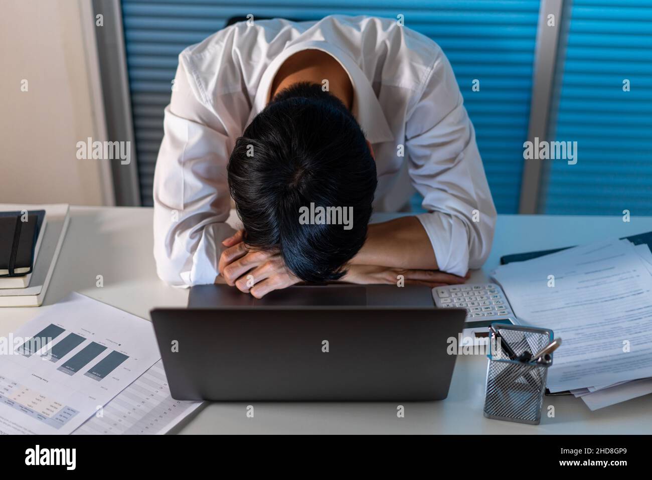 Overwork Concept The man who works late in the office lying his head on ...