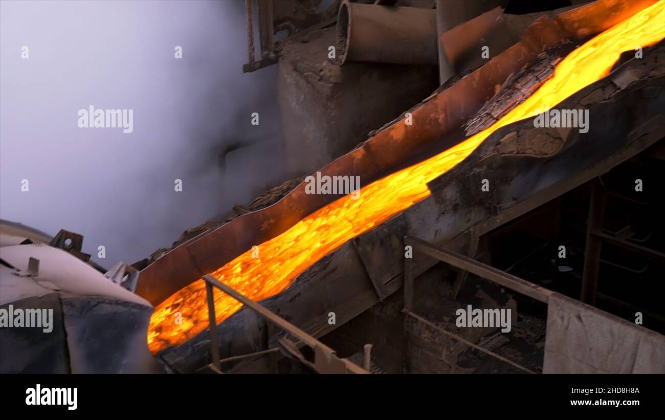 Liquid metal from flowing from blast furnace. Industrial background ...