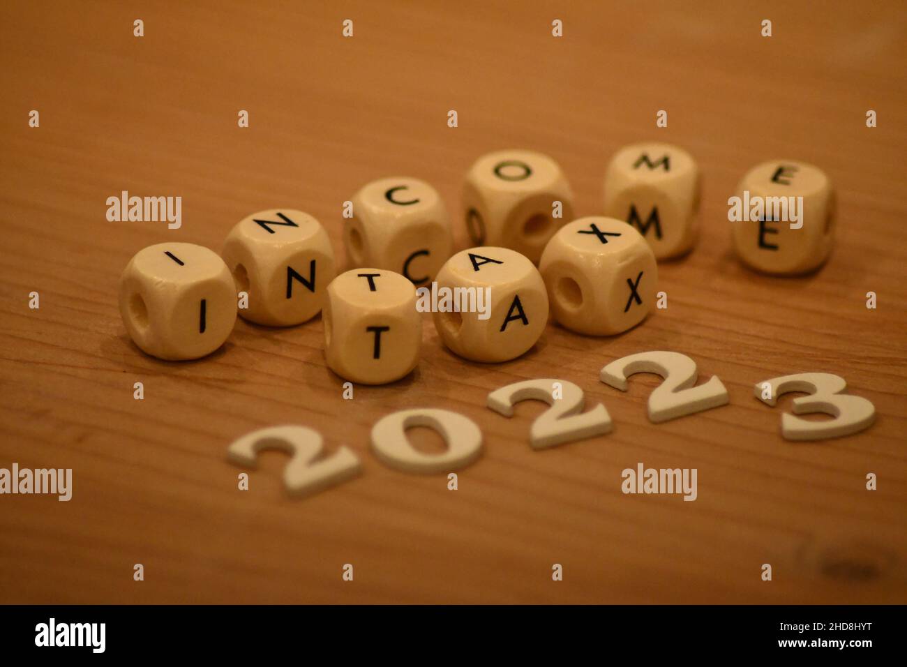 Lettered wooden blocks and wooden numbers spelling out Income Tax 2022 ...