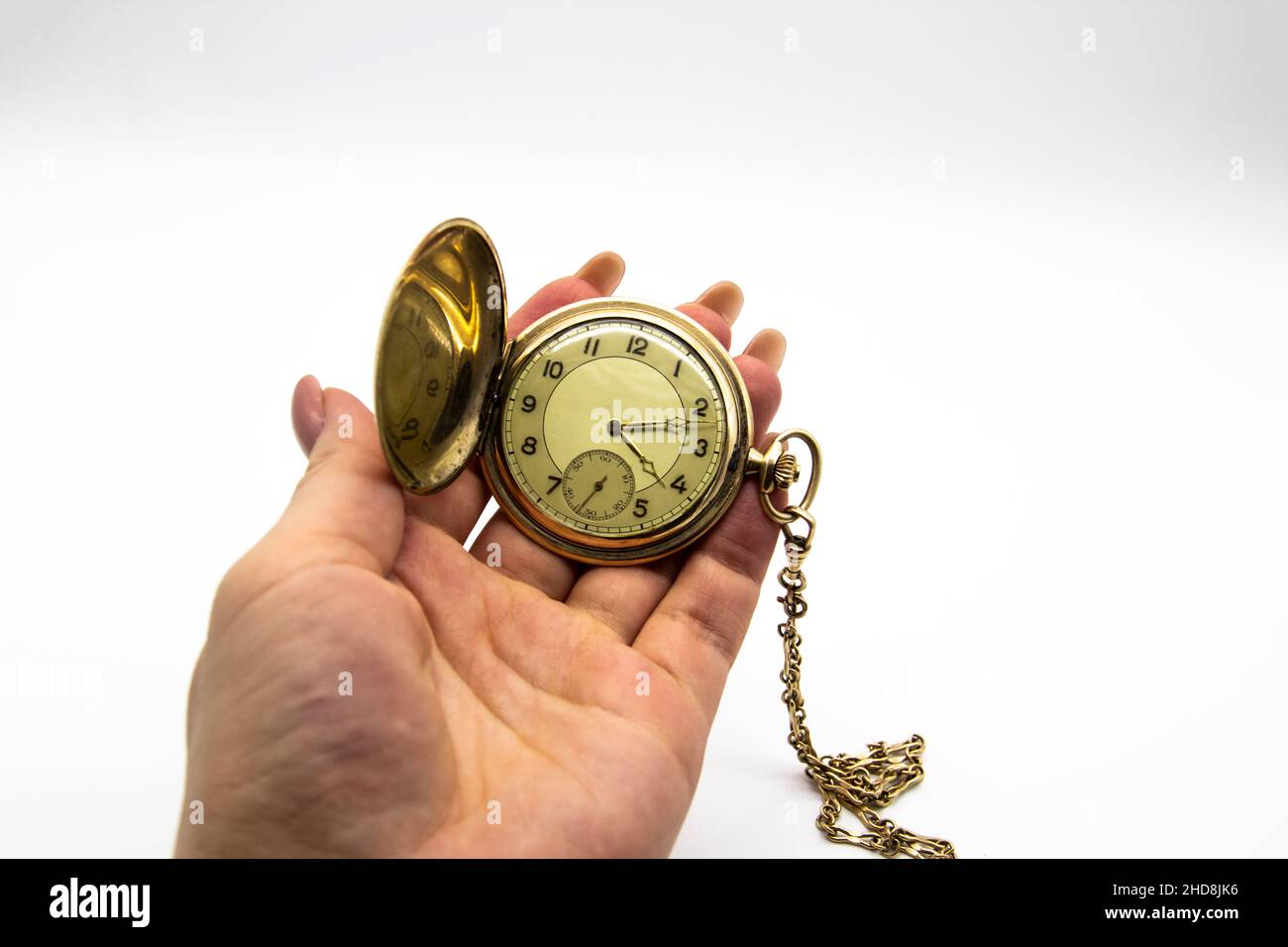 Vintage golden old pocket watch on the hand against white background ...
