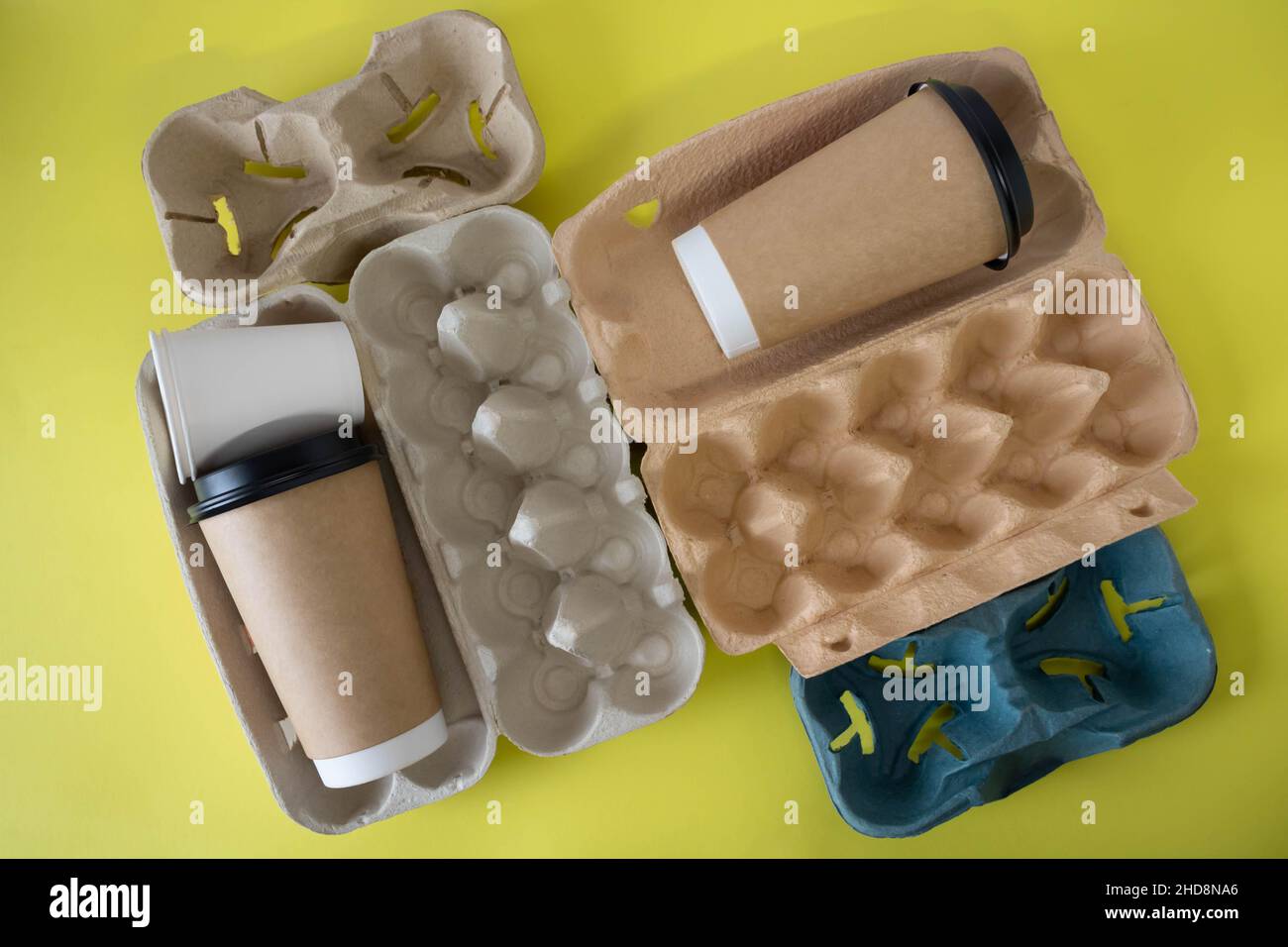 Eco-friendly food containers made of paper on a yellow background ...