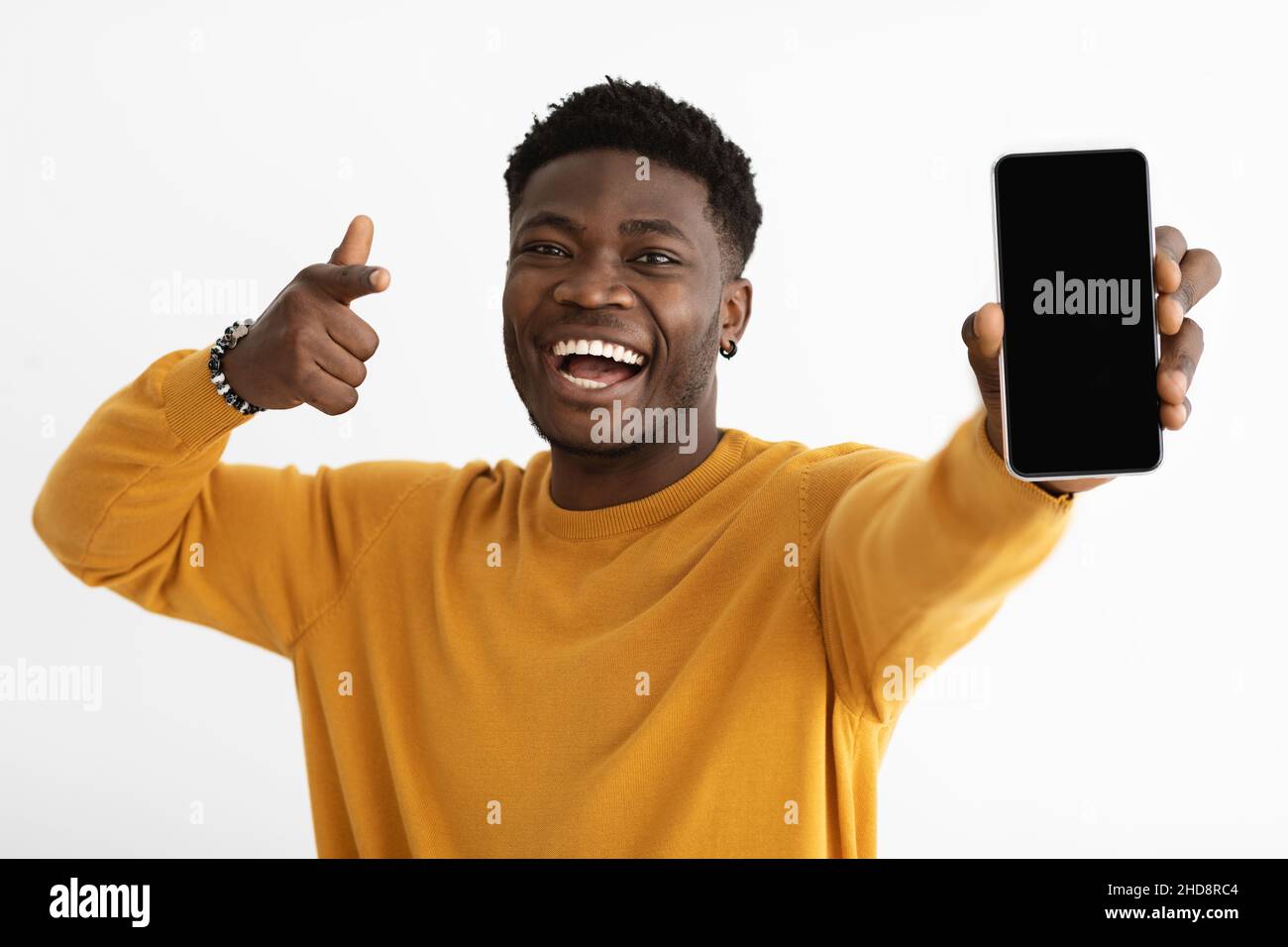 Happy black man showing mobile phone with blank screen Stock Photo - Alamy