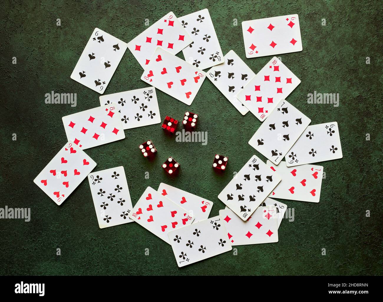 Scattered playing cards and dice on a green textured surface Stock ...