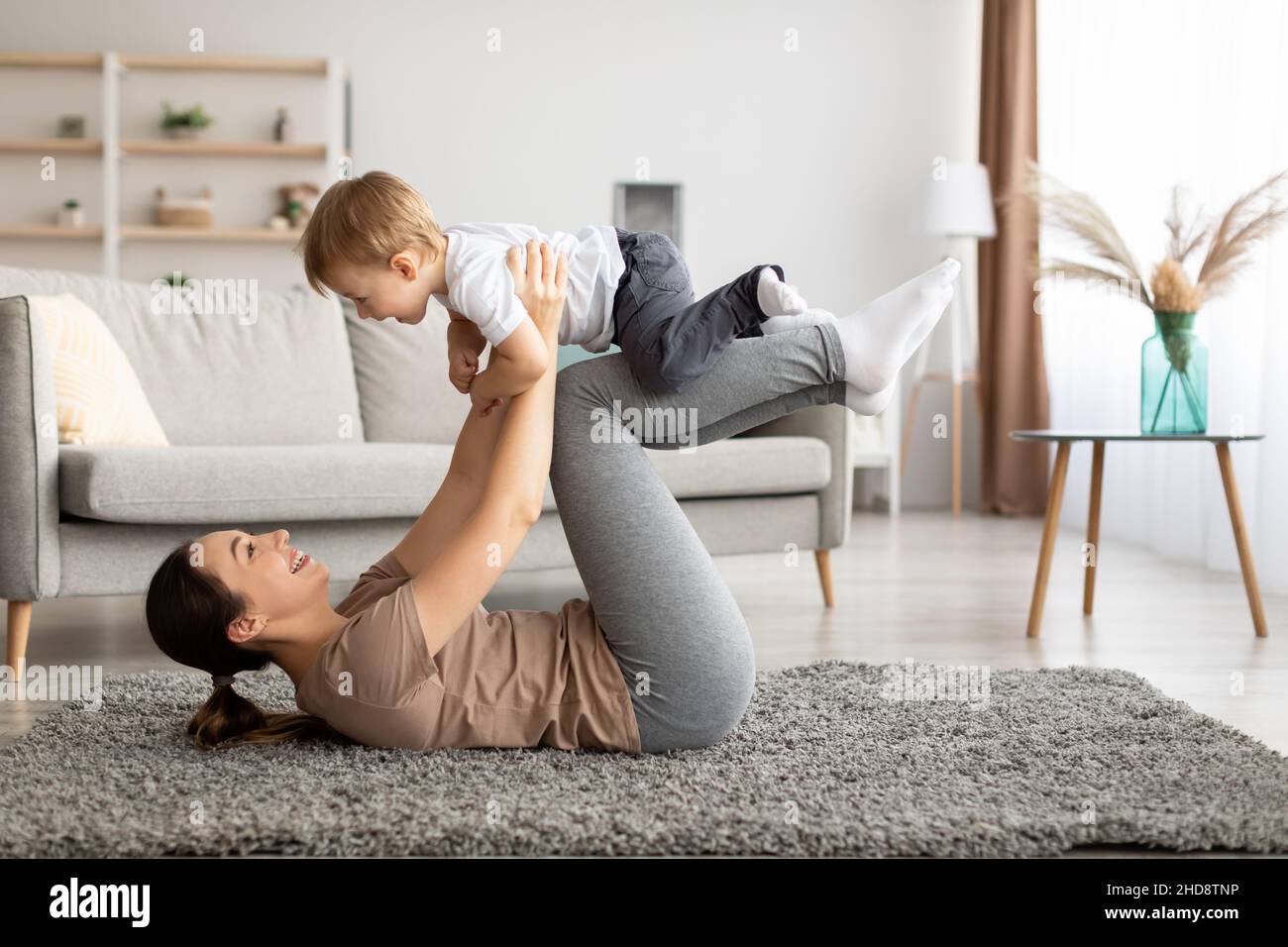Sport activities with baby. Young mother exercising with her toddler ...