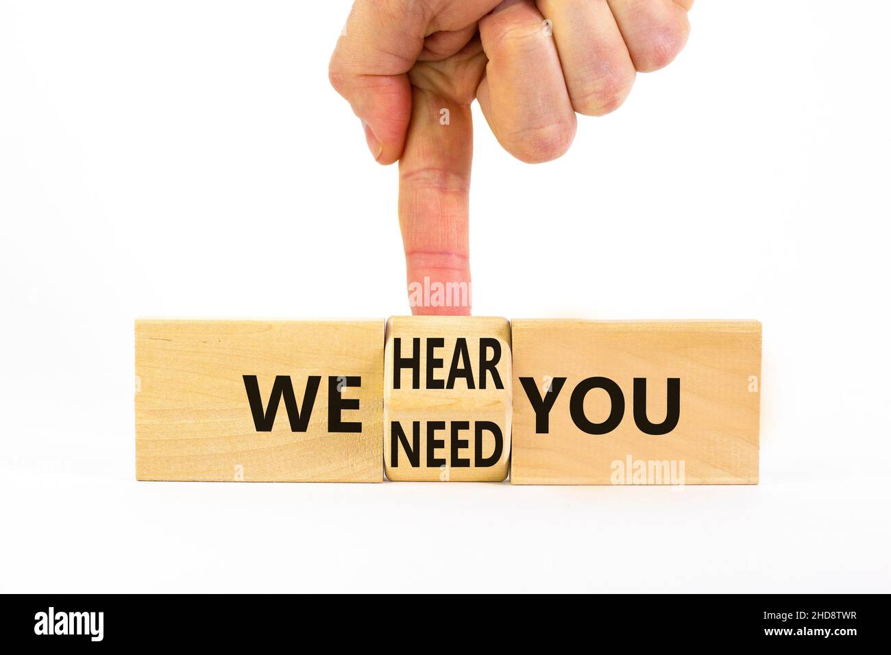 We need and hear you symbol. Businessman turns the wooden cube and ...